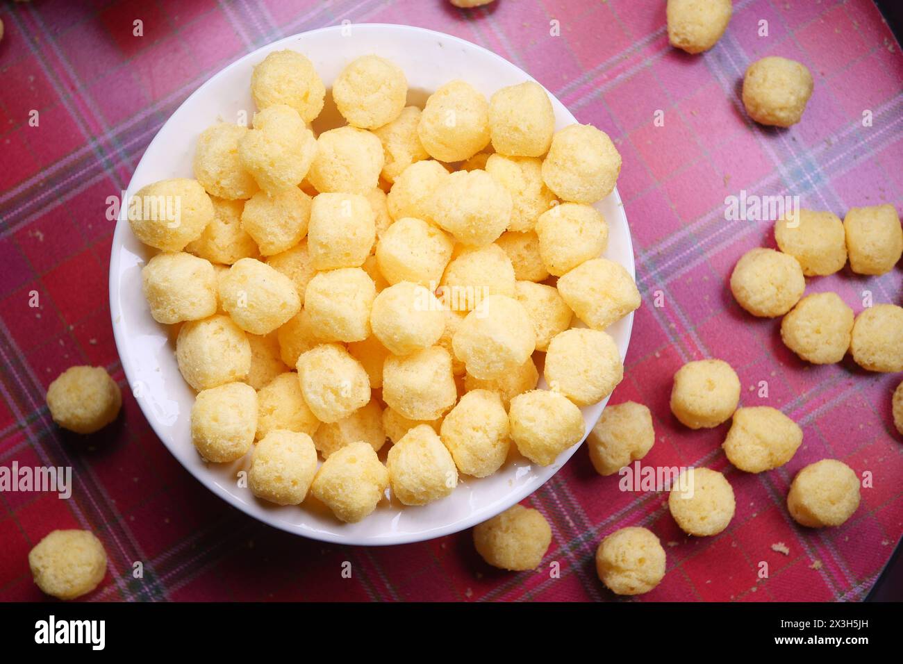 puffed corn rings chips on black background Stock Photo - Alamy