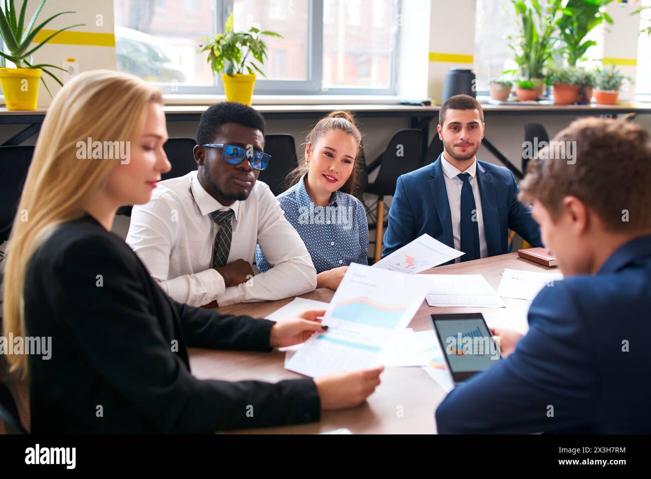 Female boss leads business meeting with diverse team in modern office ...