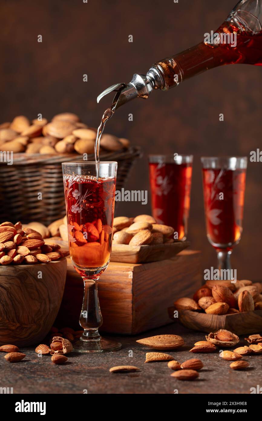 Italian liqueur Amaretto with almonds nuts on a vintage table. Liqueur ...