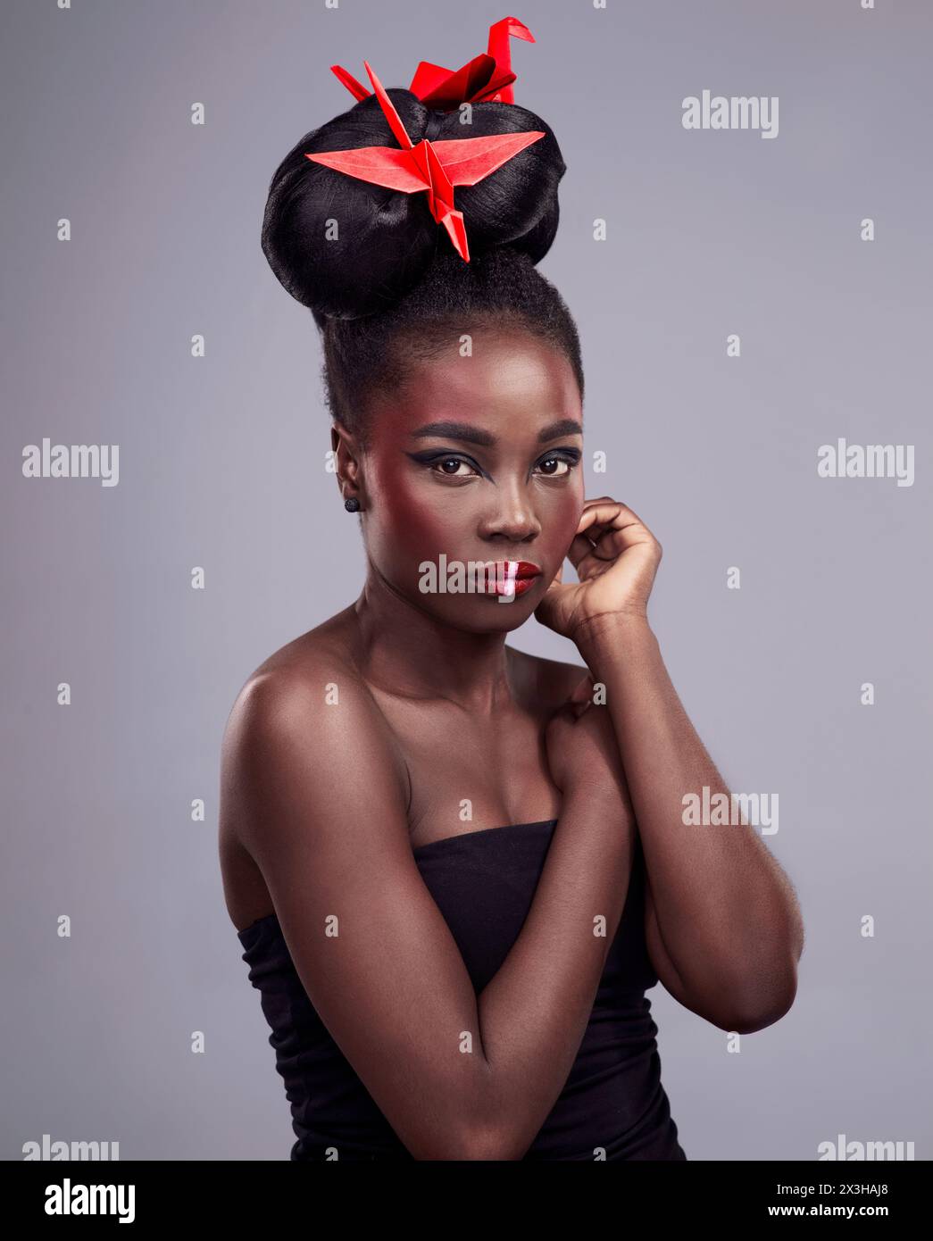 Woman, face makeup and origami in studio for beauty with red color ...