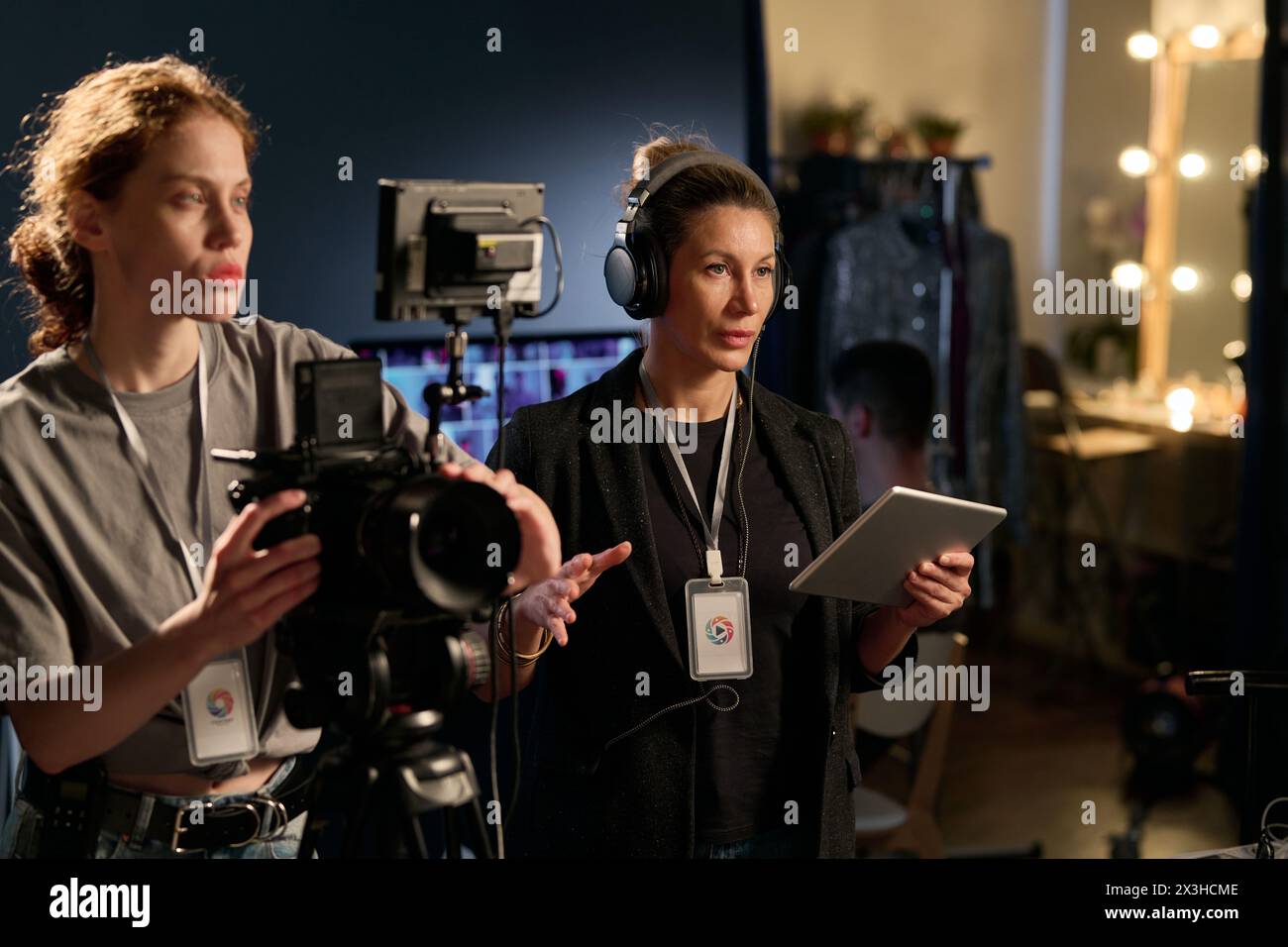 Waist up portrait of female director giving instructions to cast and ...
