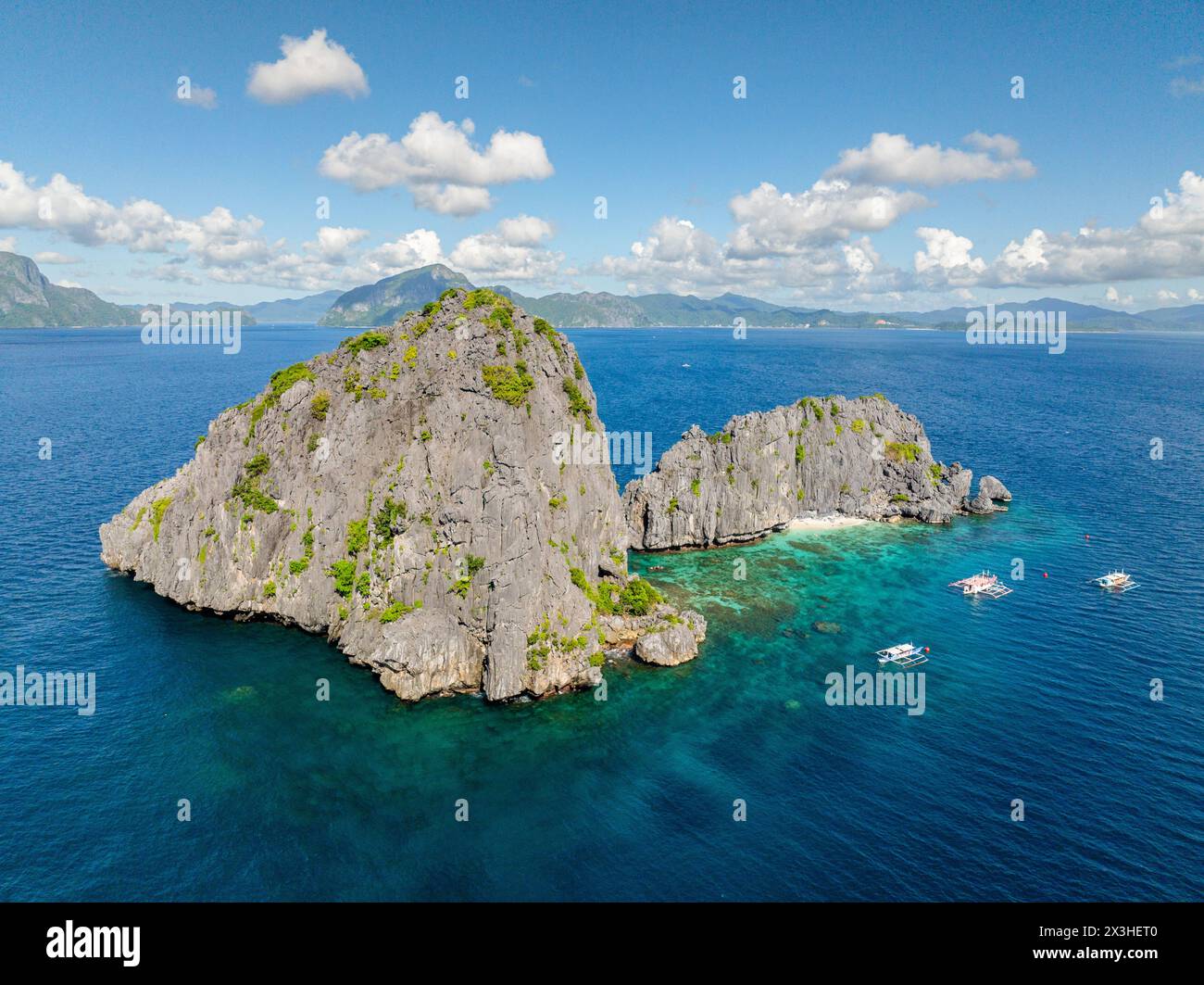 Tourist boats over the blue sea in Twin Rocks. Blue sky and clouds. El ...