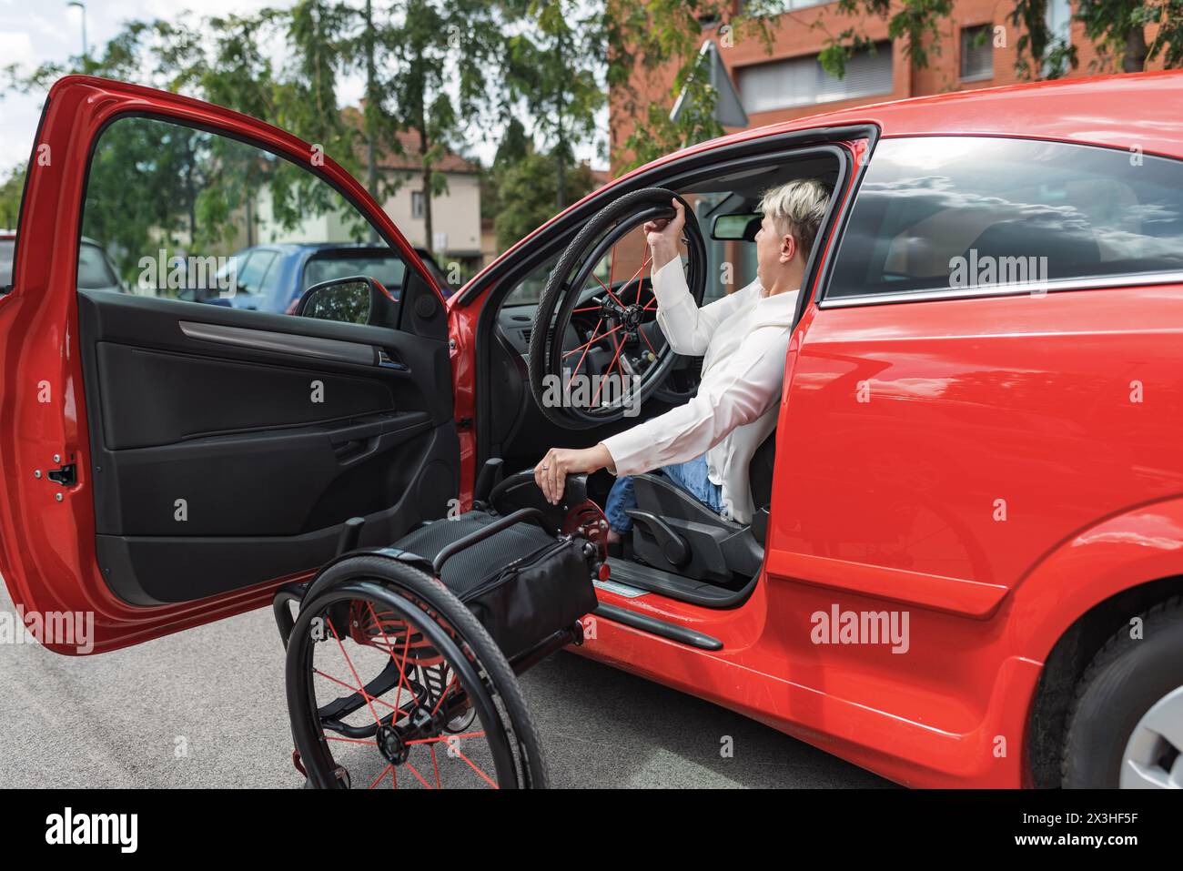 Smiling woman with disability sitting in the driver seat and lifting ...