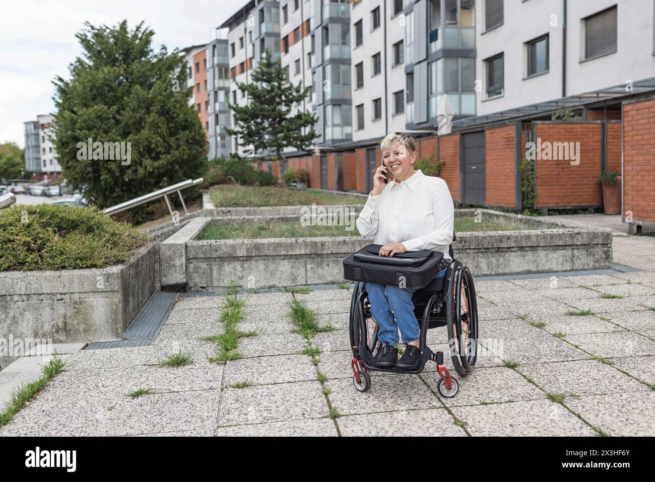 Smiling business lady with disability, a wheelchair user talking on a ...