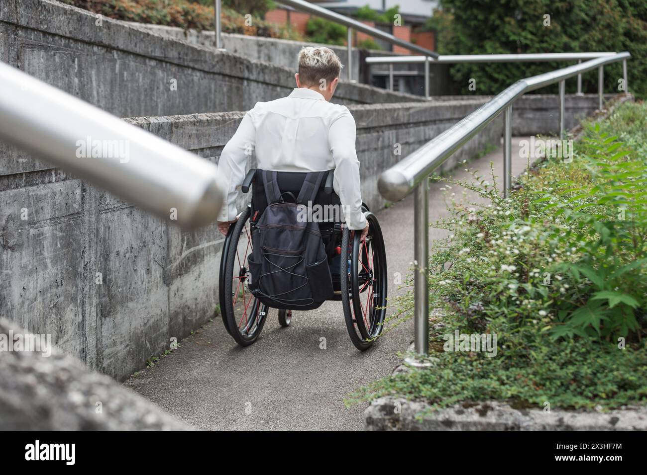 Person with physical disability moving in a manual wheelchair along the ...