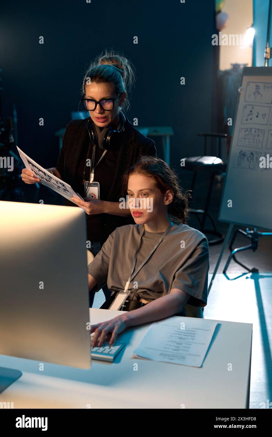 Vertical portrait of two women working in video production crew and ...