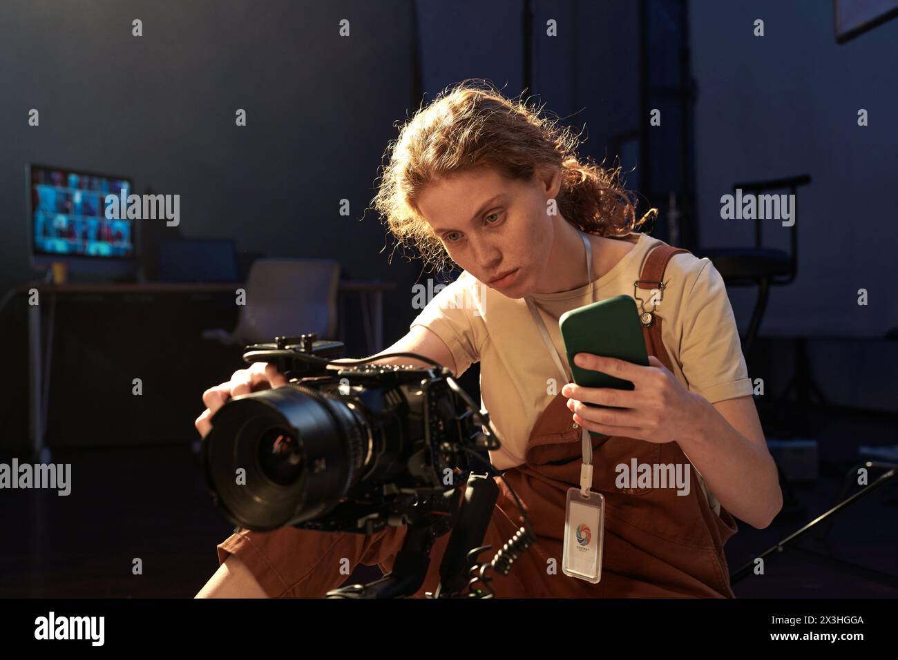 Professional cameraman setting camera in hi-res stock photography and ...