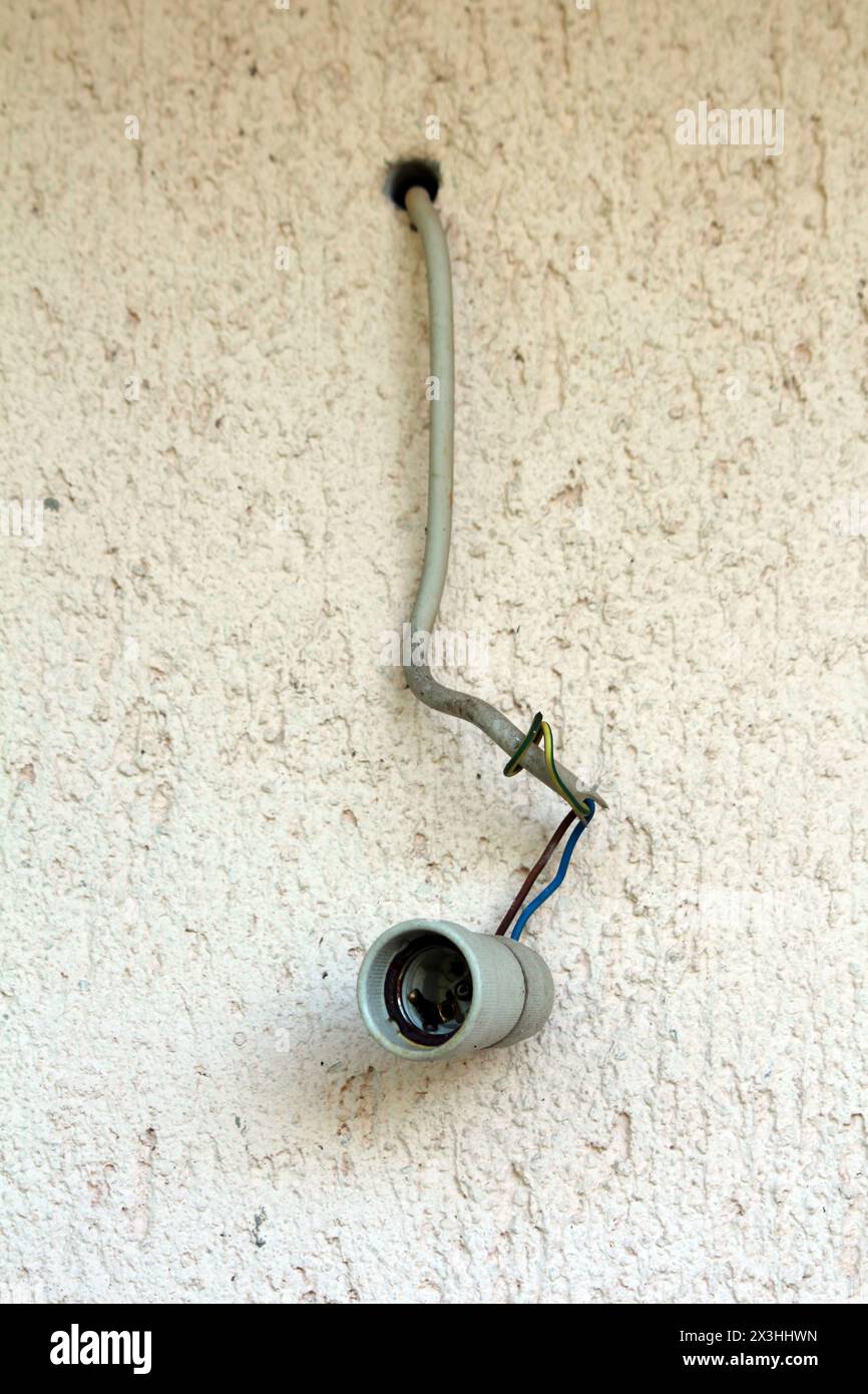 Old E27 type ceramic light bulb socket hanging from brown and blue ...