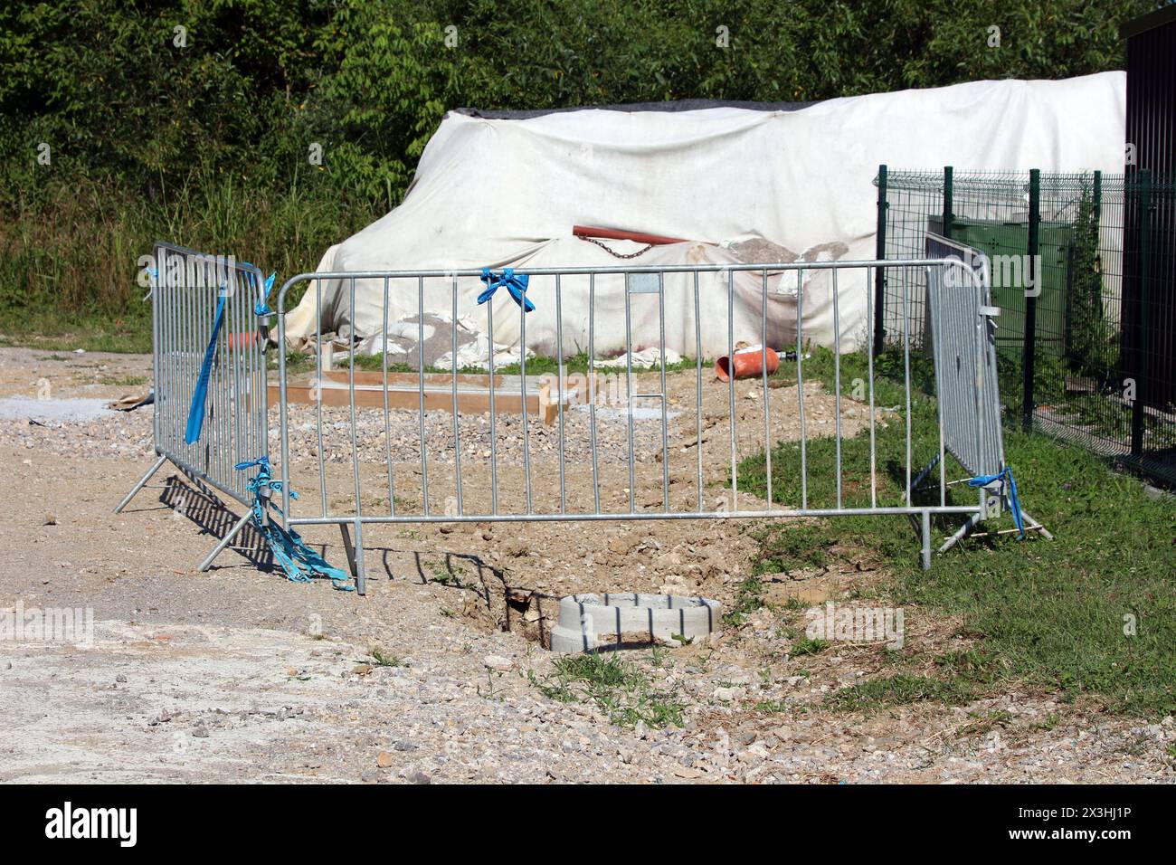 Temporary construction metal fence panels preventing access to open ...