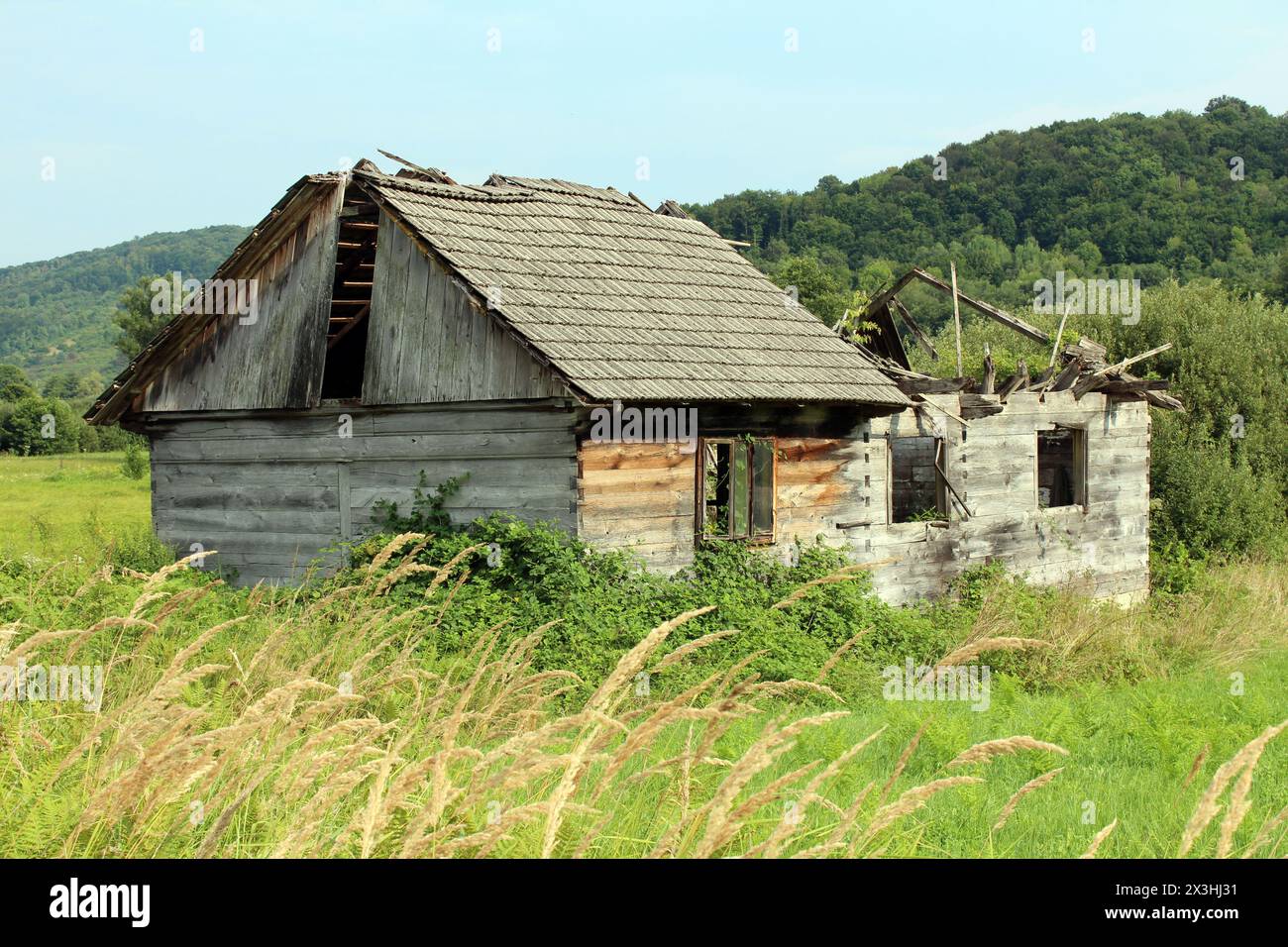 Vintage abandoned old dilapidated wooden family house with destroyed roof and broken windows ...