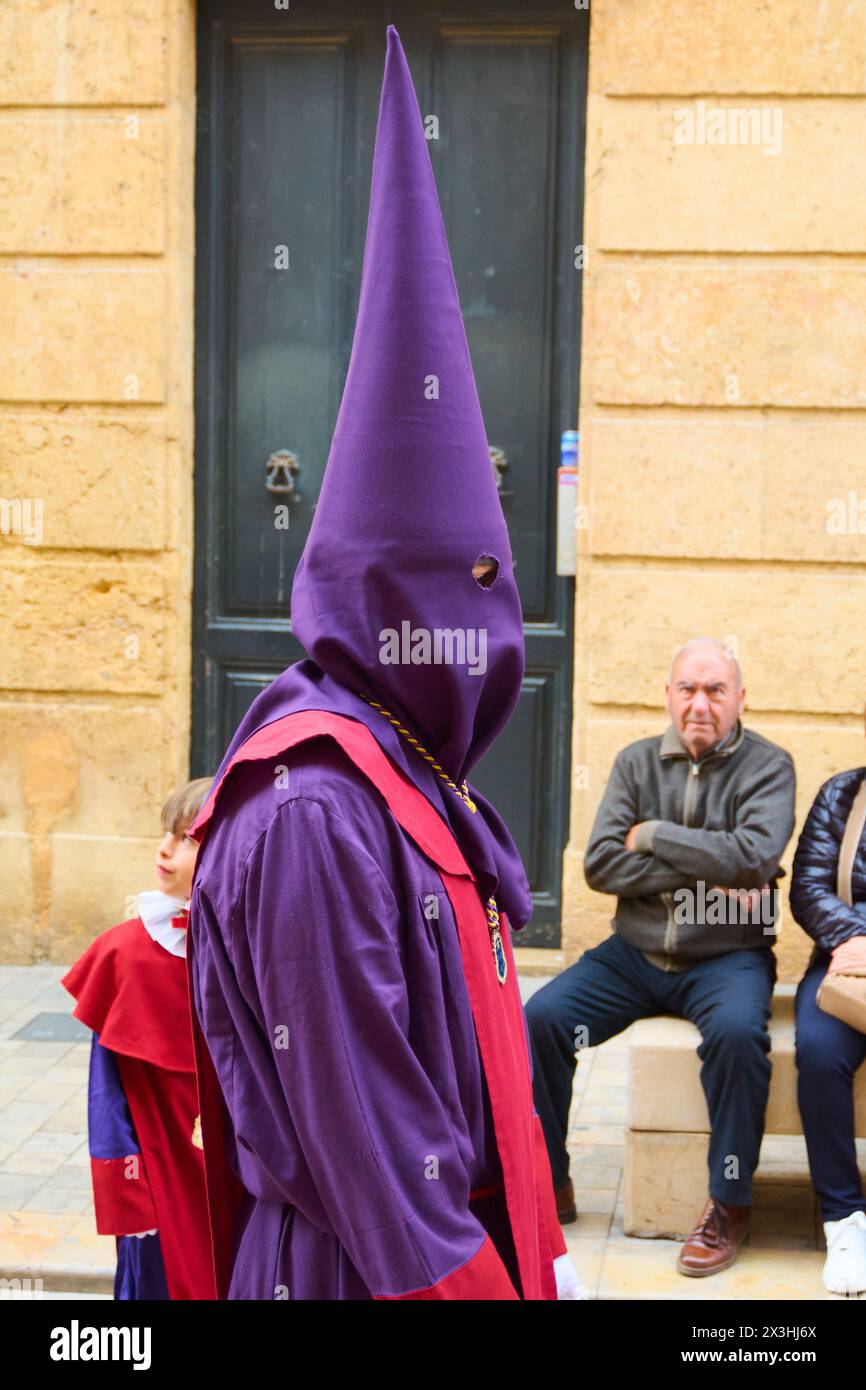 Tarragona, Spain - April 27, 2024: Devout participants in red robes and ...