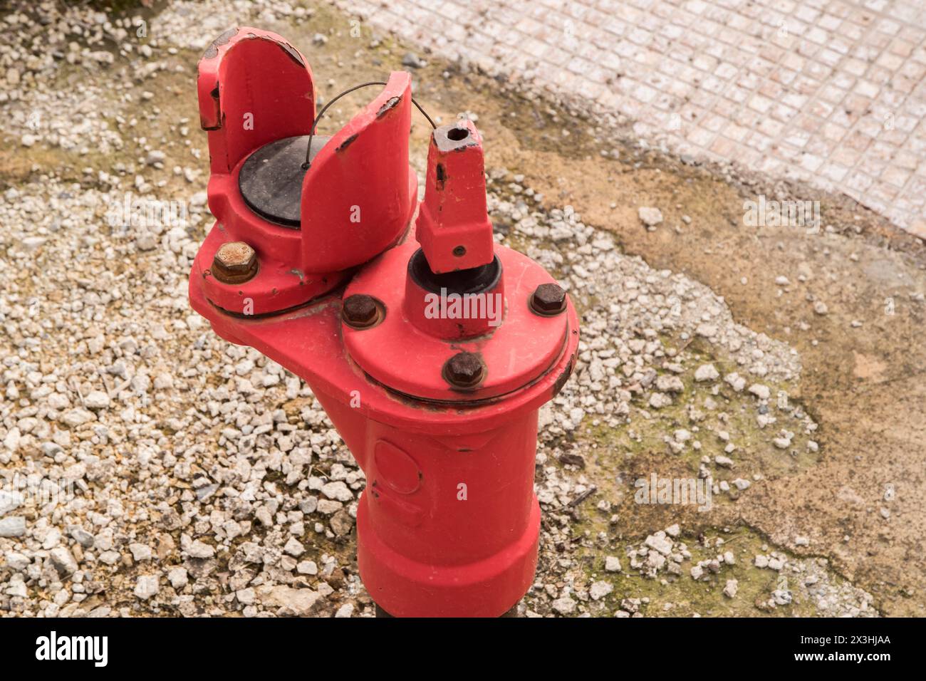 Red fire hydrant closeup on ground Stock Photo - Alamy