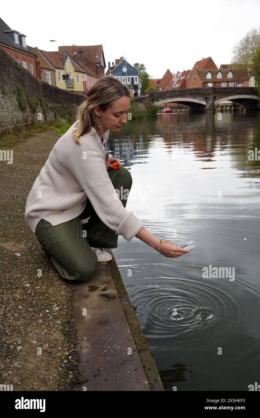 River Action Communities Coordinator Chloe Peck takes a water sample ...