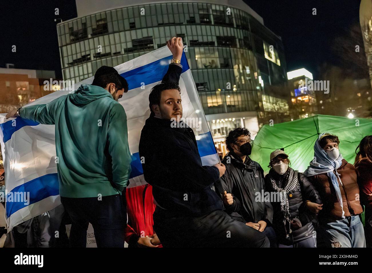 Pro-Palestine protesters lock arms on the edges of the encampment while ...