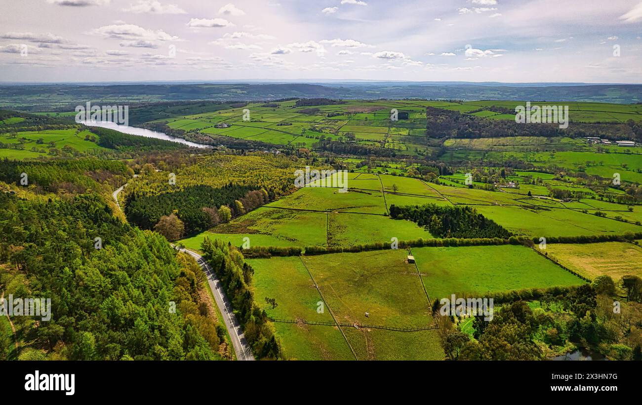Aerial view of a lush green landscape with a winding river, fields, and ...