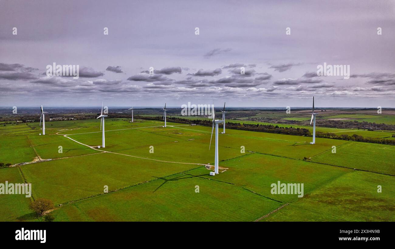 Aerial view of a wind farm with multiple turbines in a lush green ...