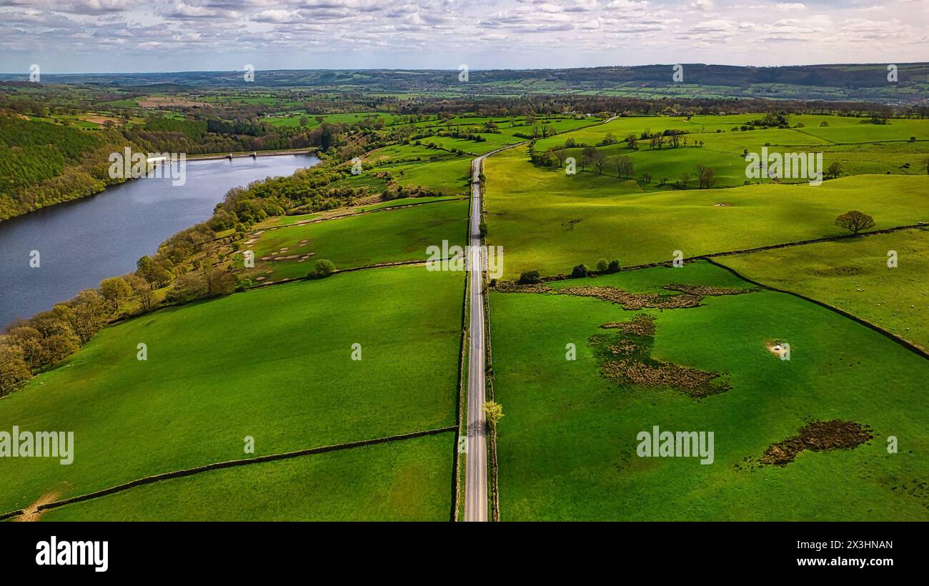 Aerial view of a lush green landscape with a road cutting through ...