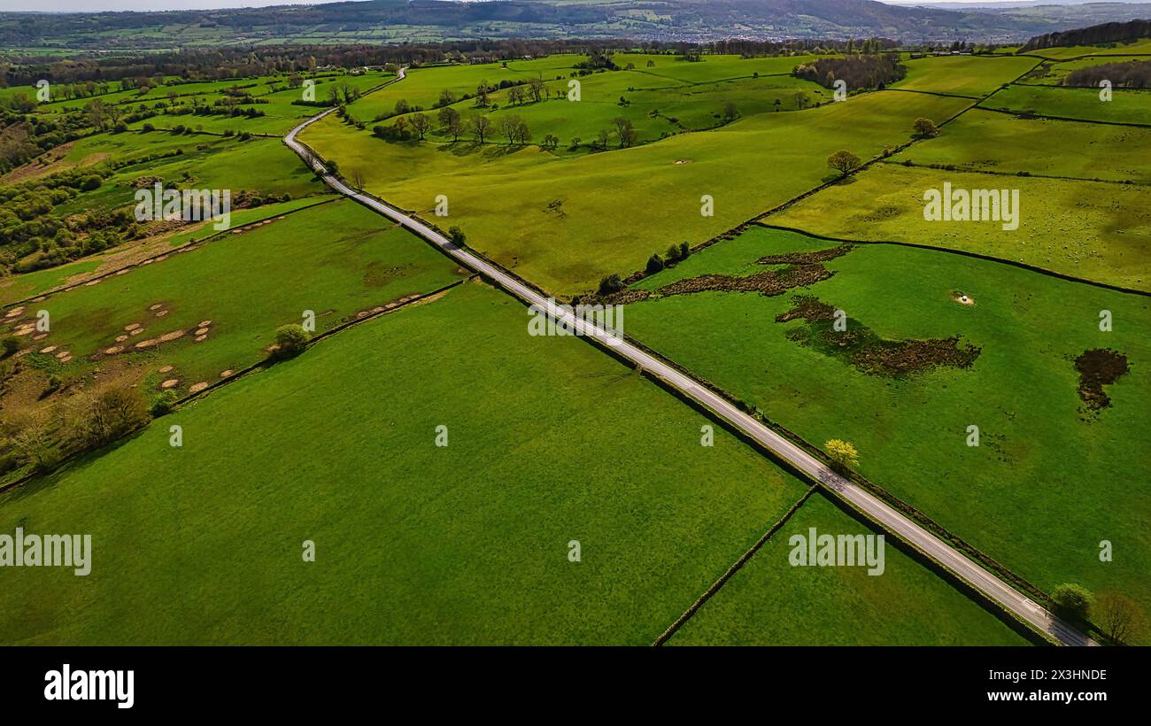 Aerial view of a lush green landscape with a winding road cutting ...