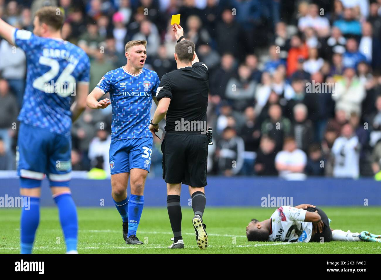 Referee, Ben Toner shows a yellow card to Harrison Neal of Carlisle ...