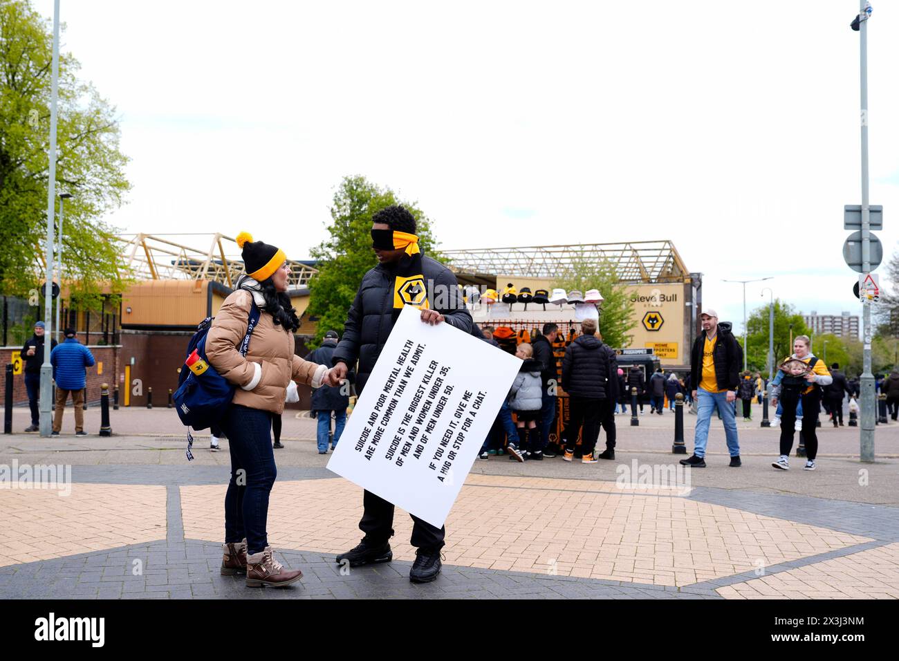 A person holds a sign encouraging people to stop for a chat outside the ...