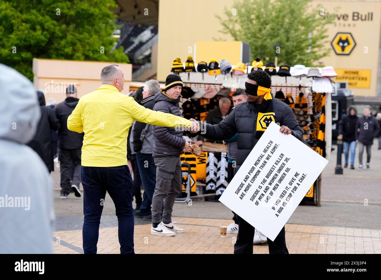 A person holds a sign encouraging people to stop for a chat outside the ...