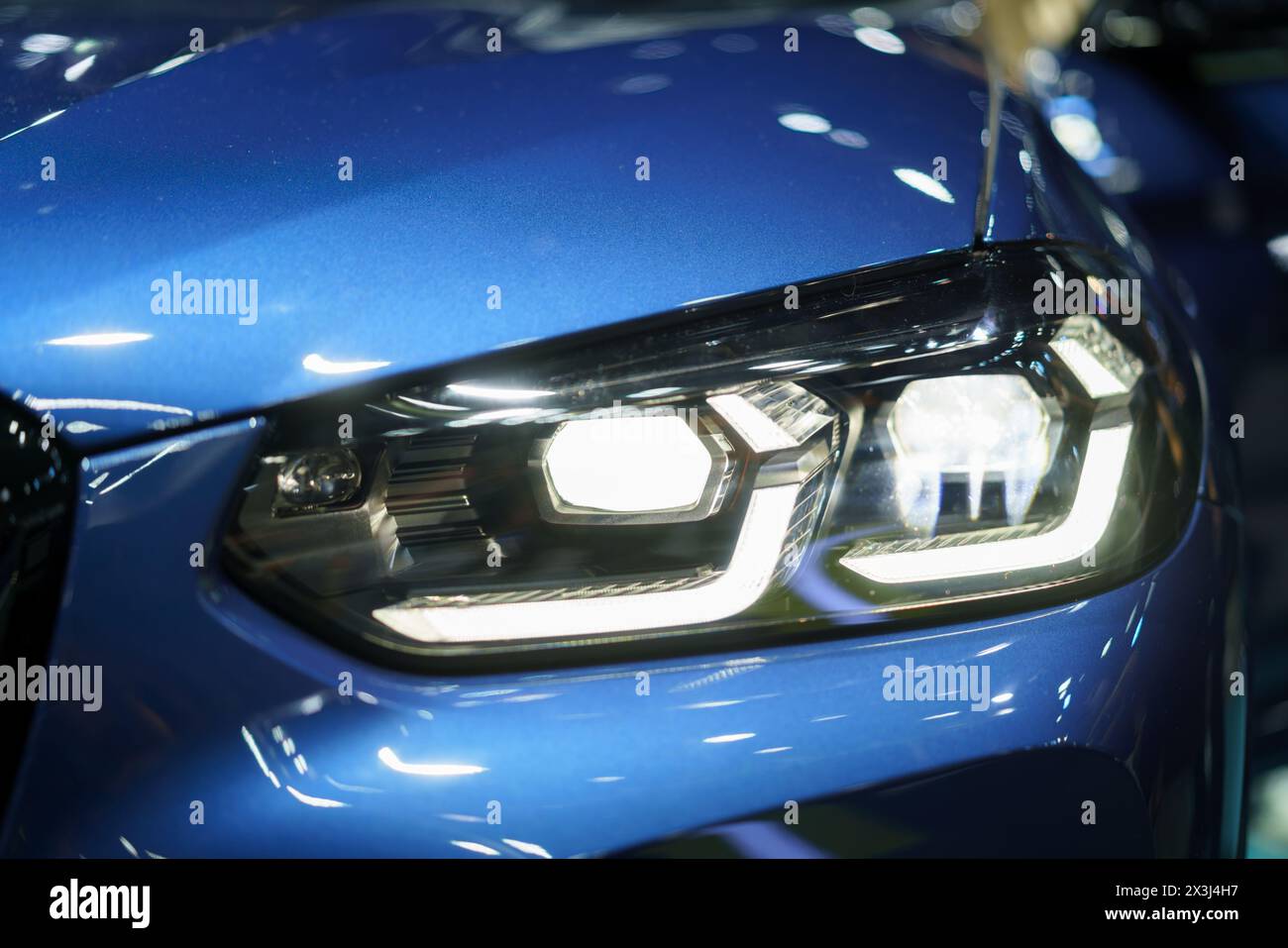 close-up shot of car headlights during nighttime illumination. The ...