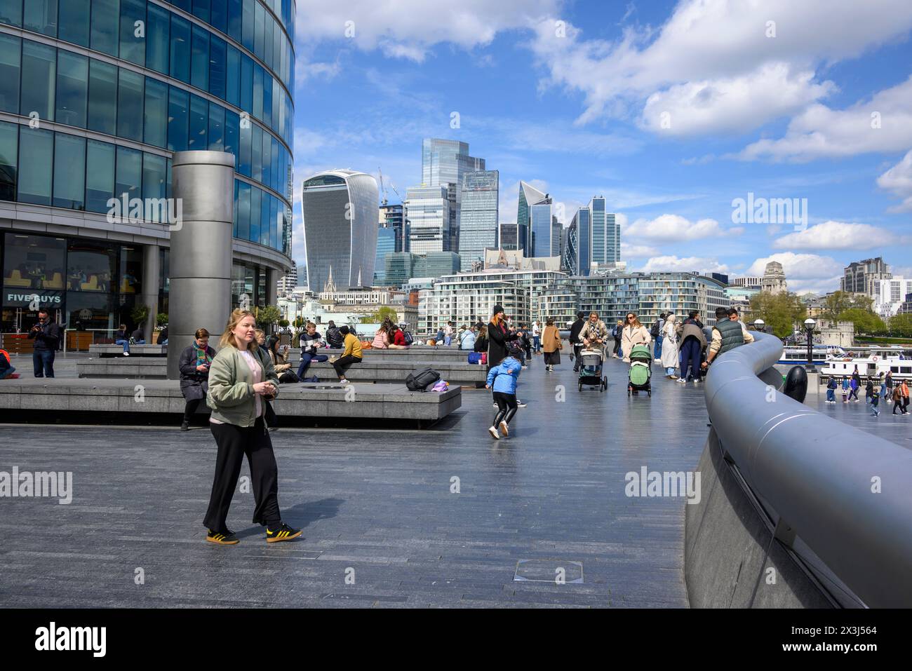 People in April sunshine at More London Riverside, looking towards City ...