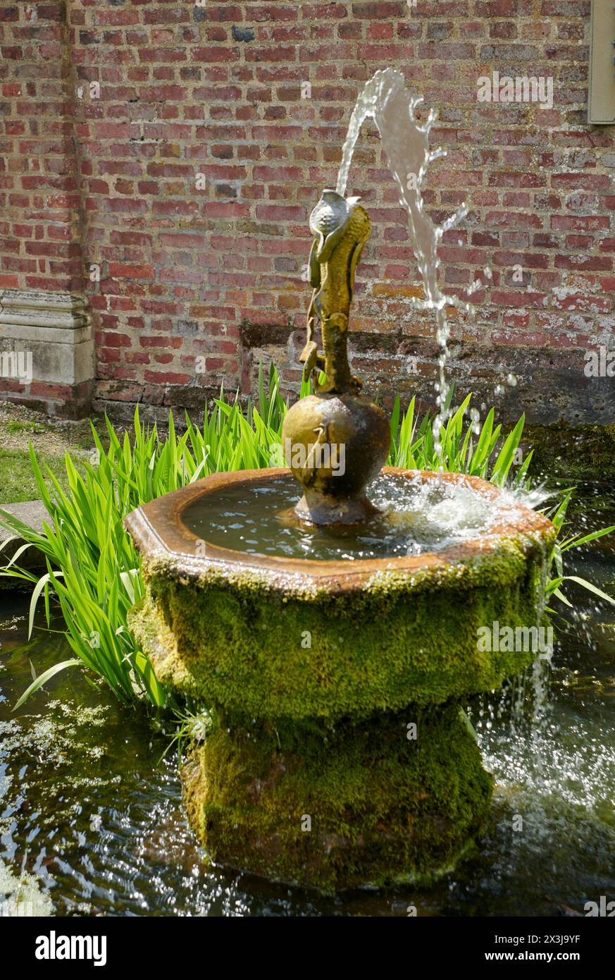 Old moss-covered fountain with a bronze sculpture in a serene garden ...