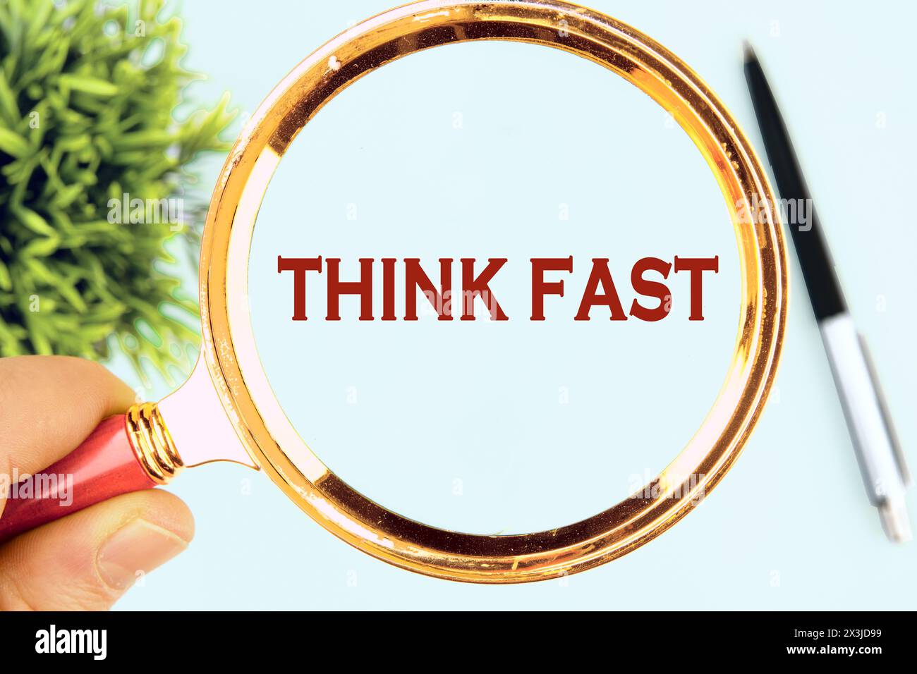 THINK FAST words written through a magnifying glass on a light ...