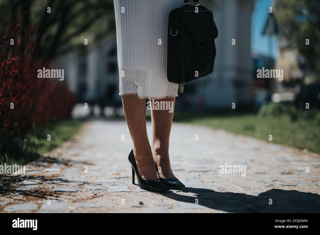 Elegant woman in high heels carrying a black backpack walking on a ...