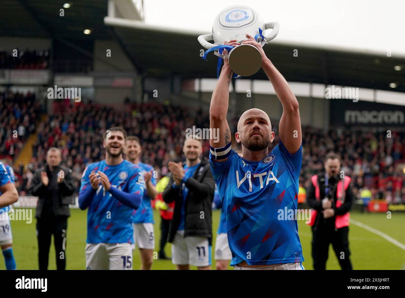 Stockport County's Paddy Madden holds aloft an inflatable trophy in ...