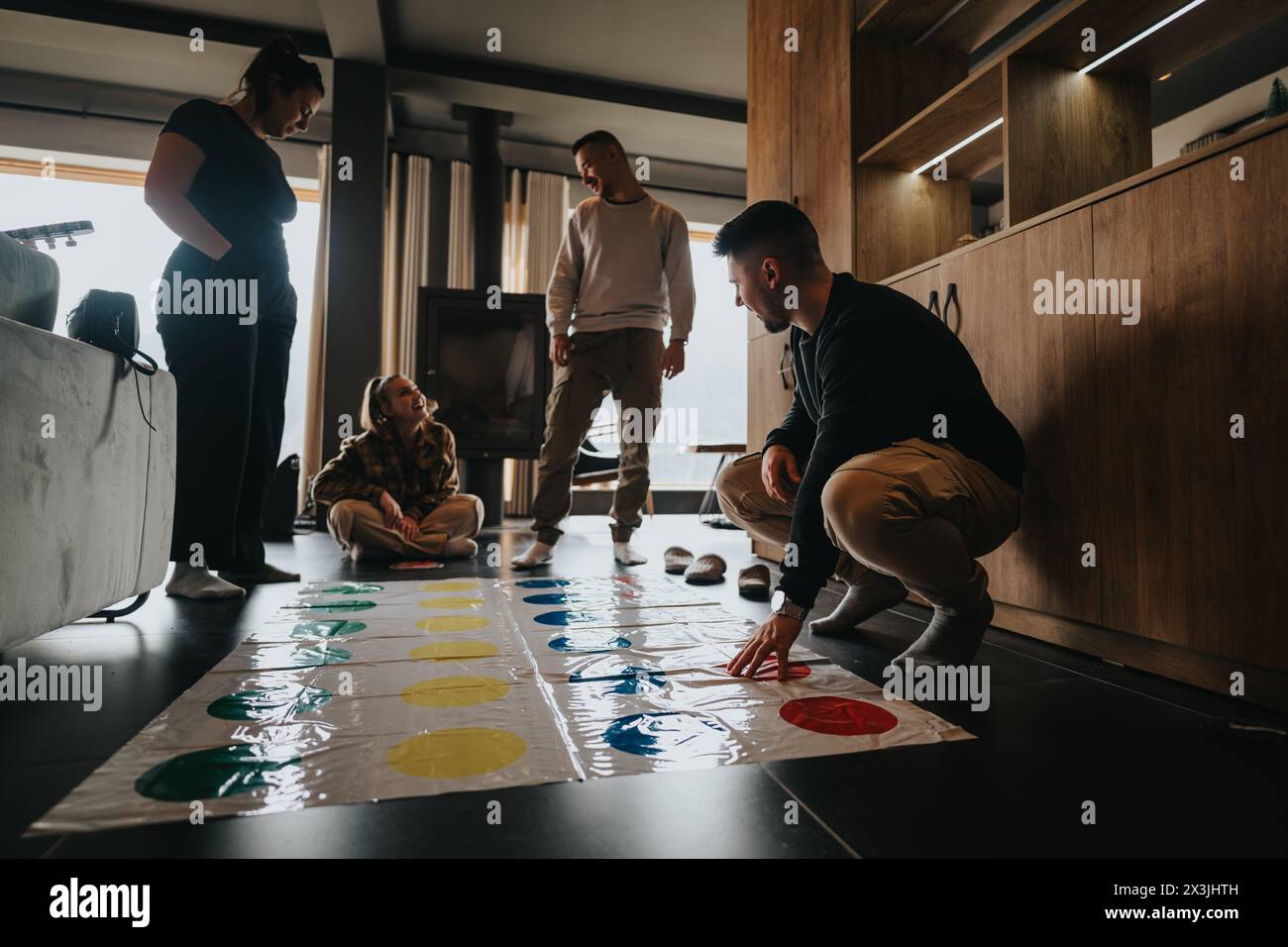 Group of friends having fun playing twister game at home Stock Photo ...