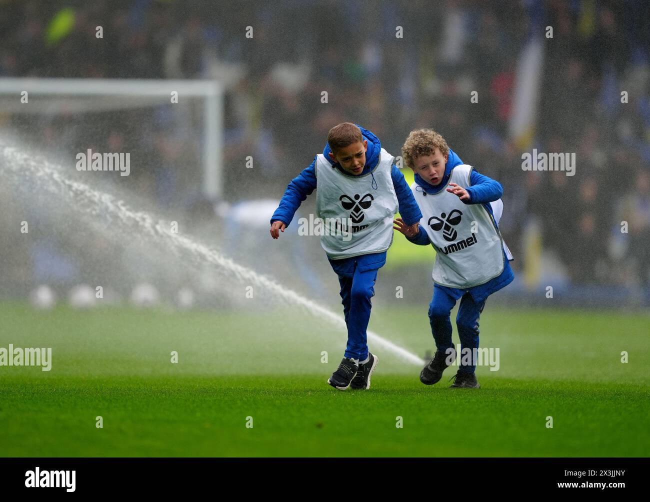 Everton ball boys are caught in the spray of the pitch sprinklers on ...