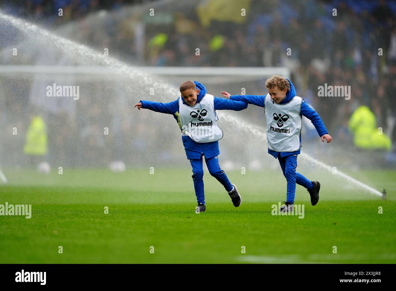 Everton ball boys are caught in the spray of the pitch sprinklers on ...