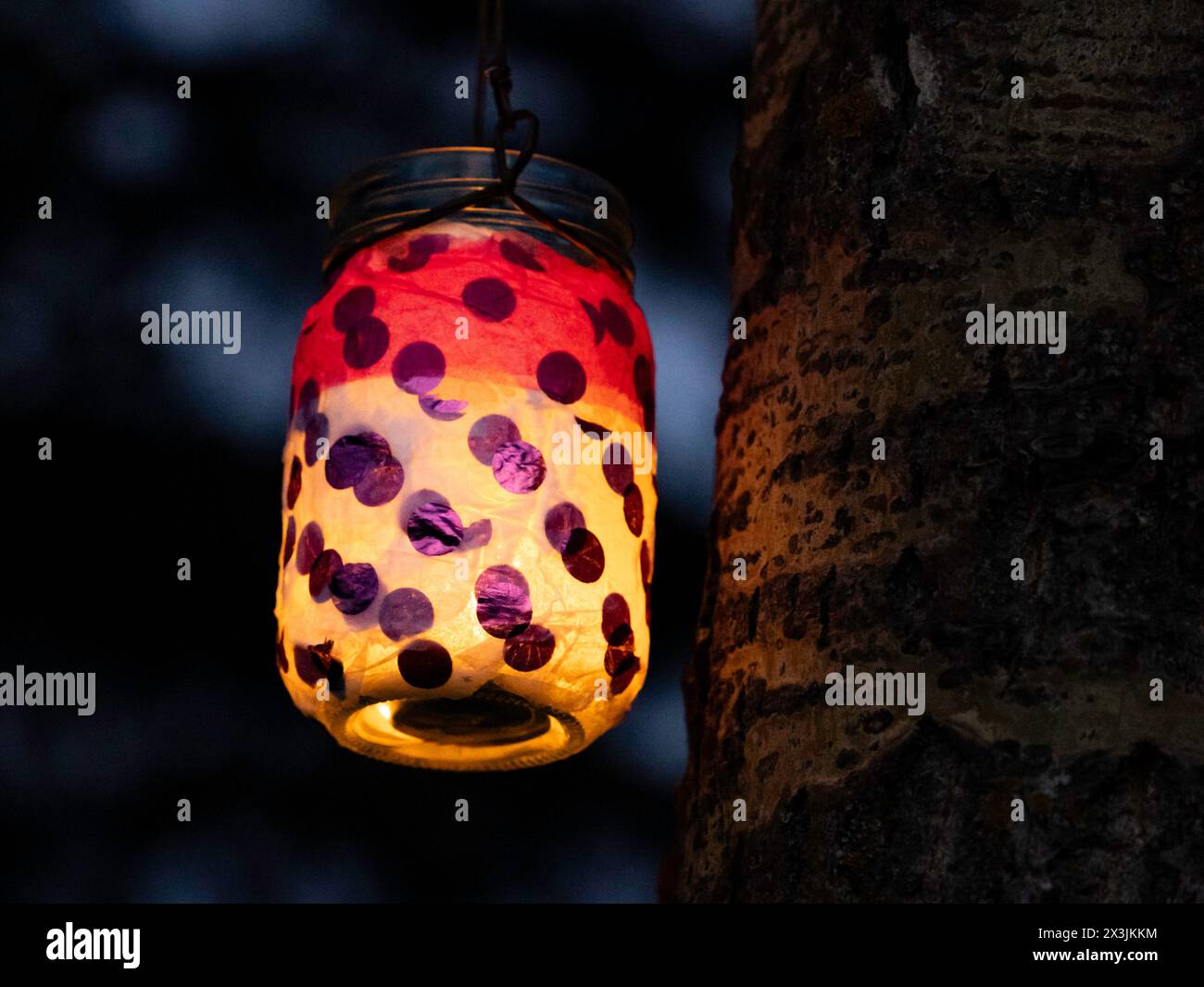 A homemade lantern made out of paper mache and a glass jar hang from a ...