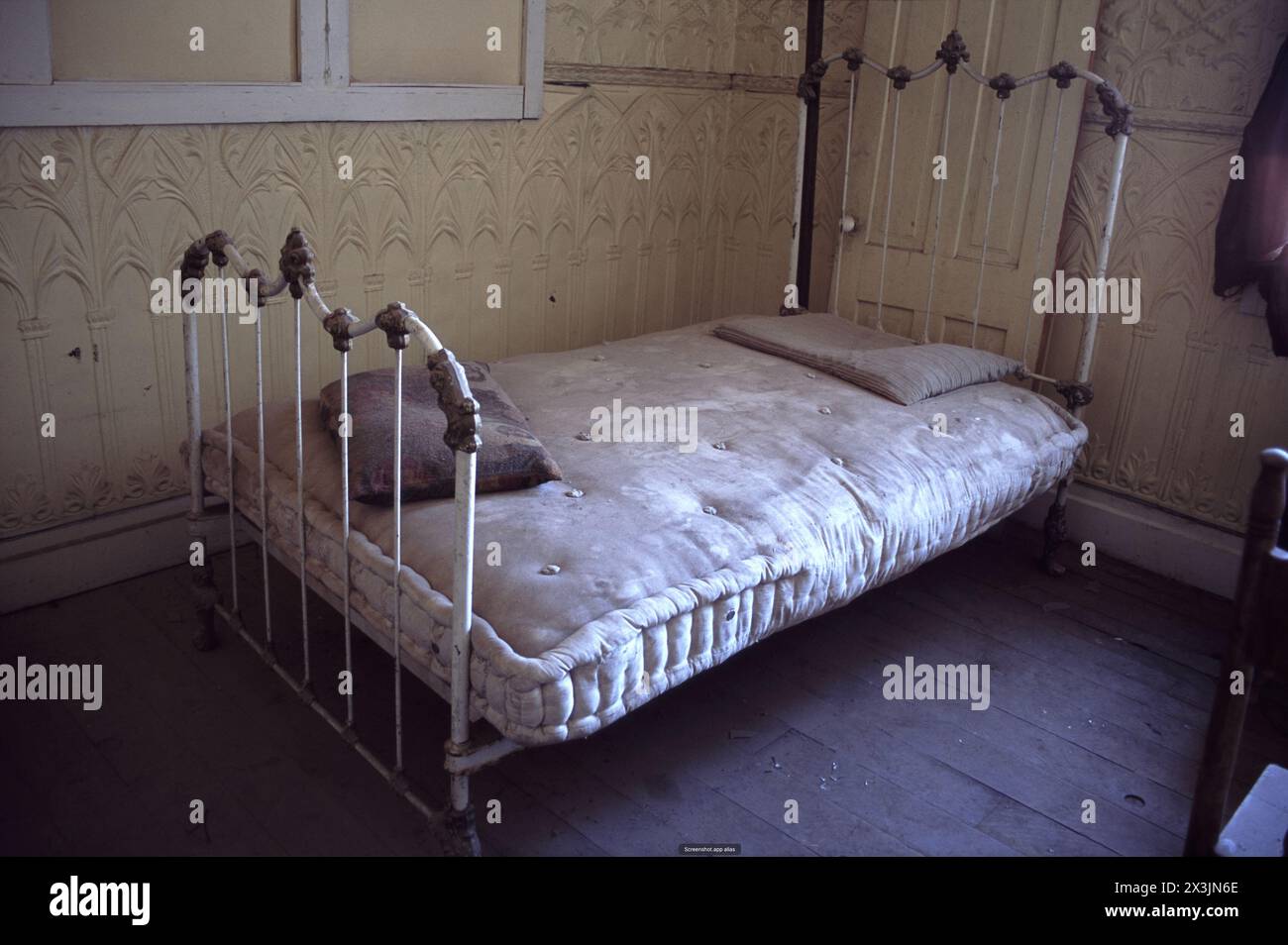 Old bed with dusty pillow, left in permanent state of arrested decay ...