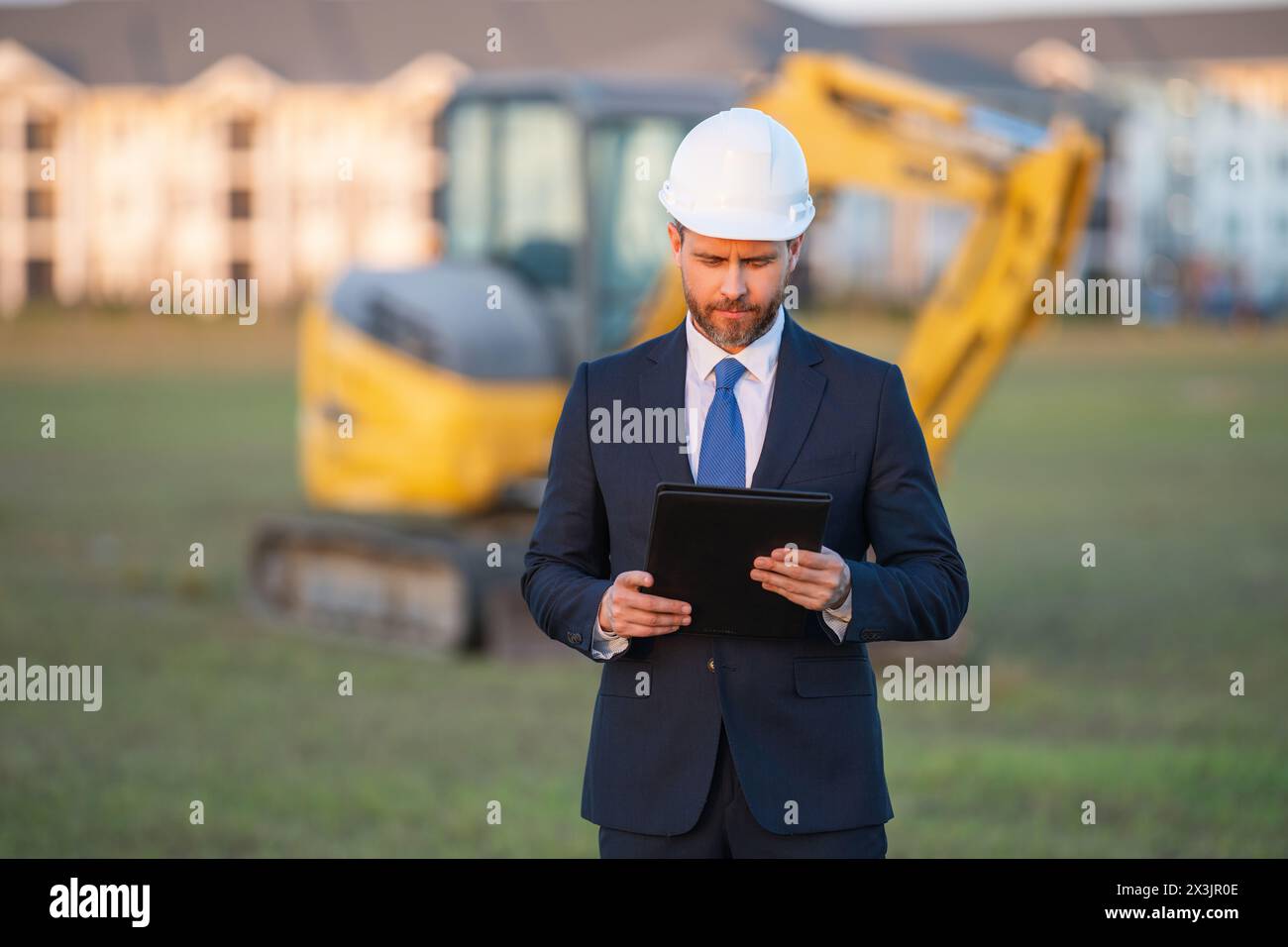 Construction owner near excavator. Confident construction owner in ...