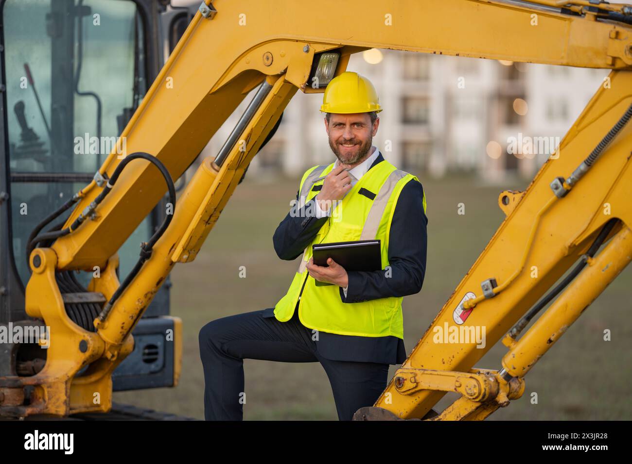 Construction owner near excavator. Confident construction owner in ...