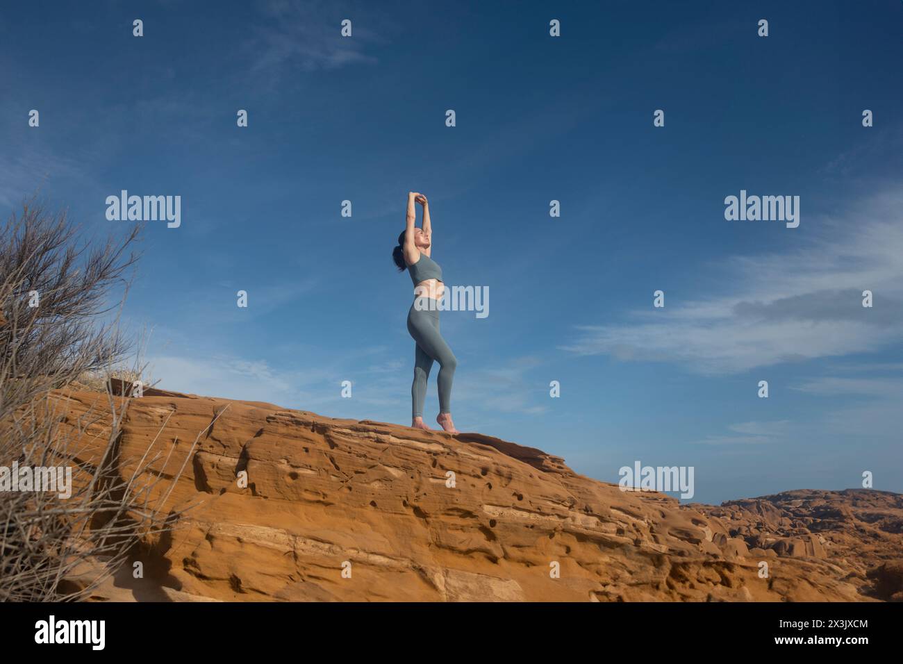 Sporty woman doing arm stretching exercises ourside, red rocks, outdoor ...