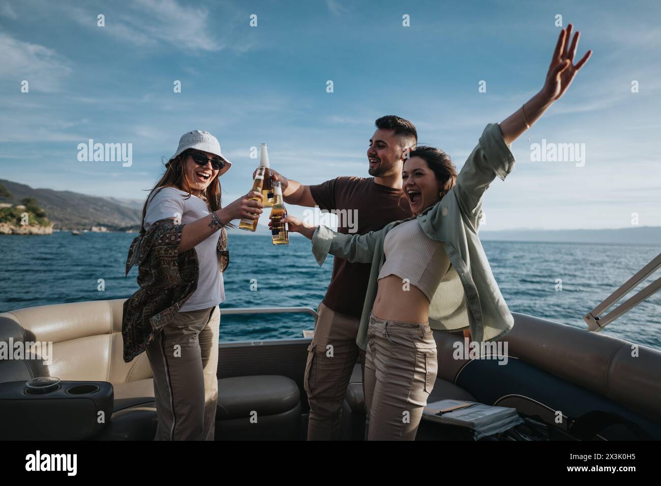 Joyful friends toasting with beers on a boat trip across the lake Stock ...