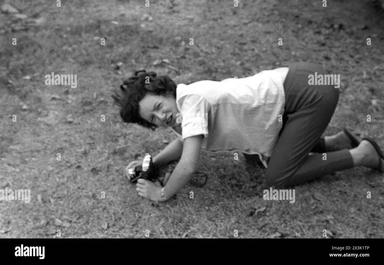 1960s, historical, a woman wearing a blouse and slacks, in a crawling ...