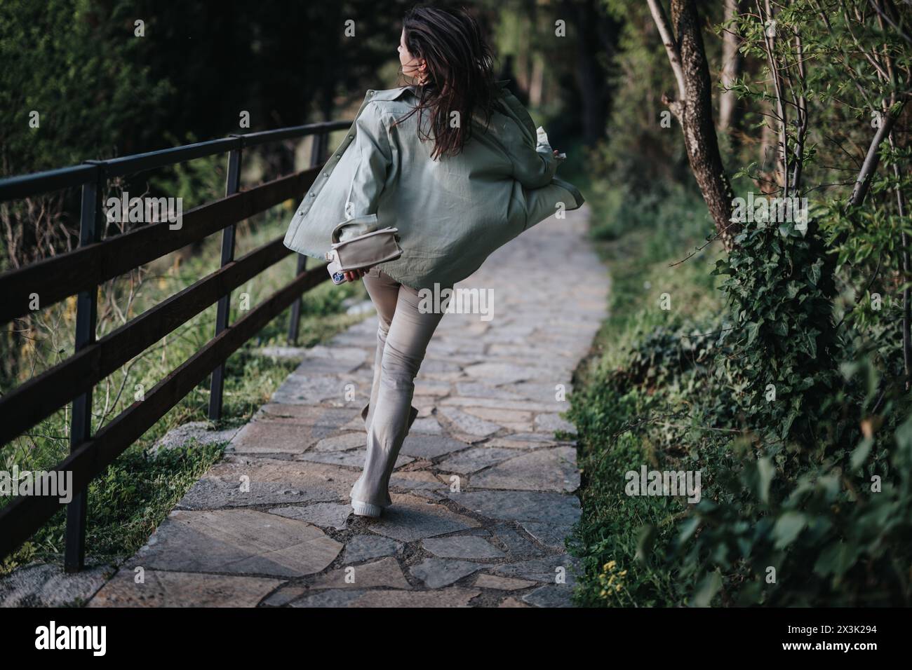 Joyful young woman walking carefree in a green park, embracing nature ...