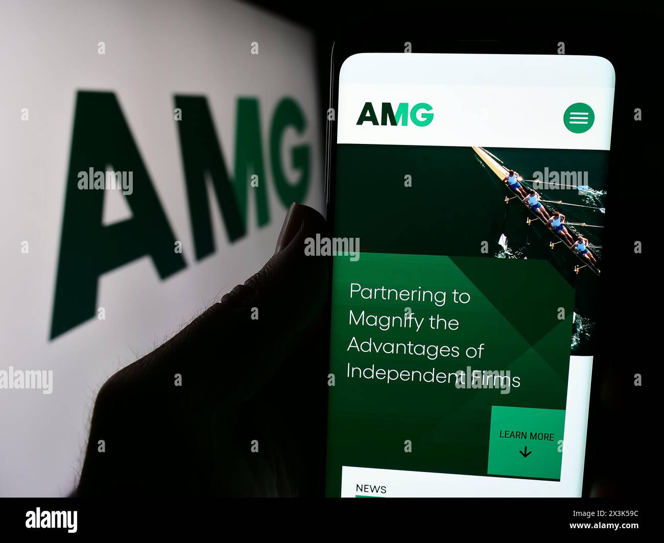 Person holding cellphone with webpage of US company Affiliated Managers ...