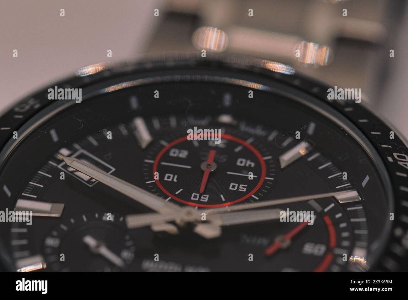 Close-up of a luxury watch with a black dial, featuring red accents and ...