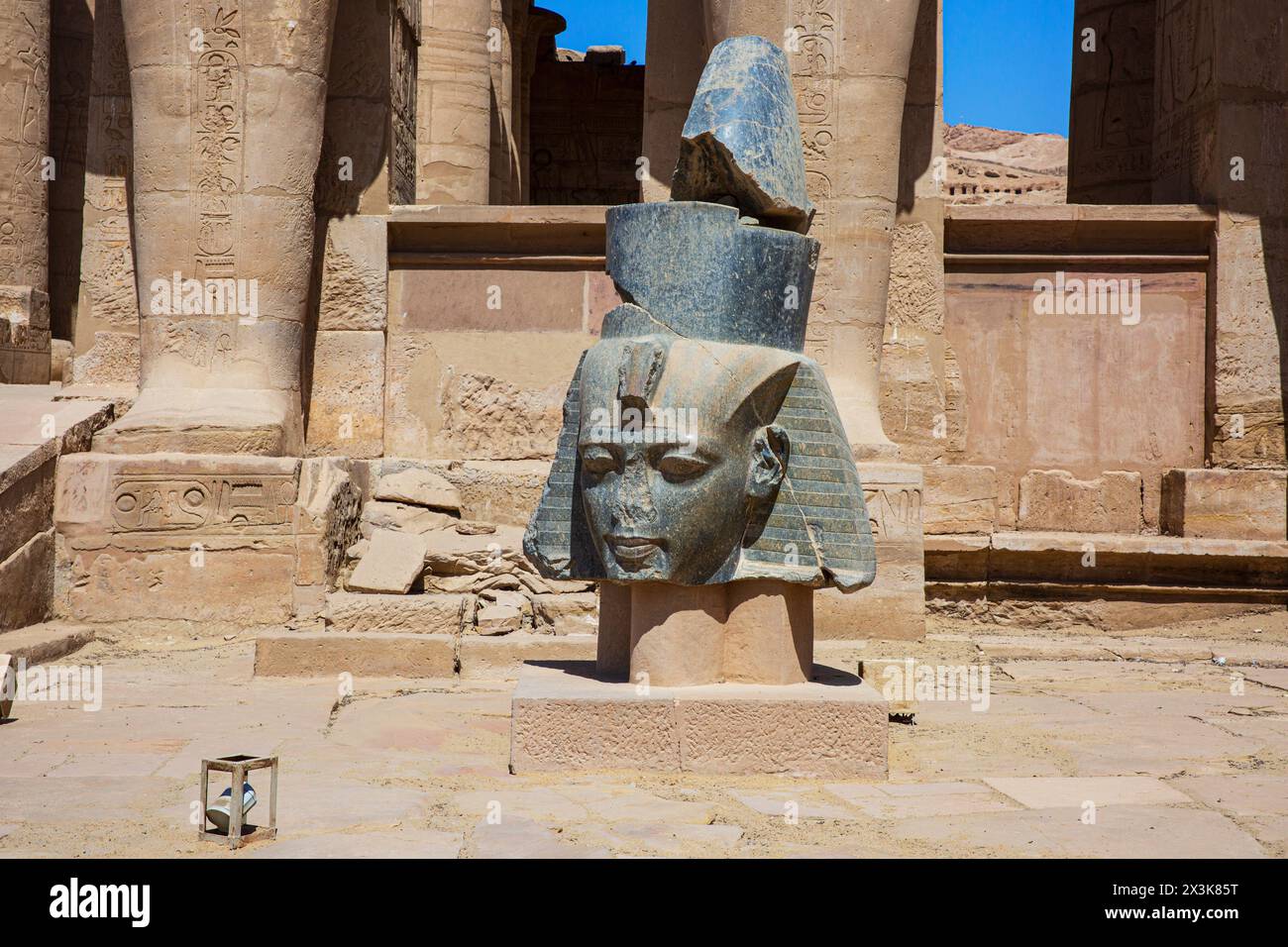 The granite head of Egyptian Pharaoh Ramesses II at the feet of the ...