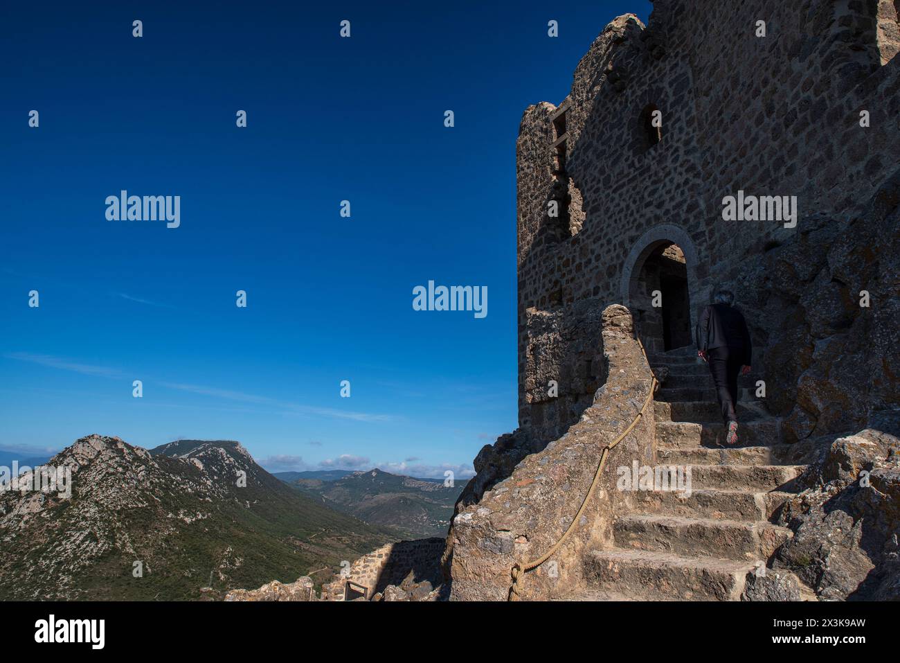 Tourist in the ruins of the medieval castle of Quéribus, in the Cathar ...