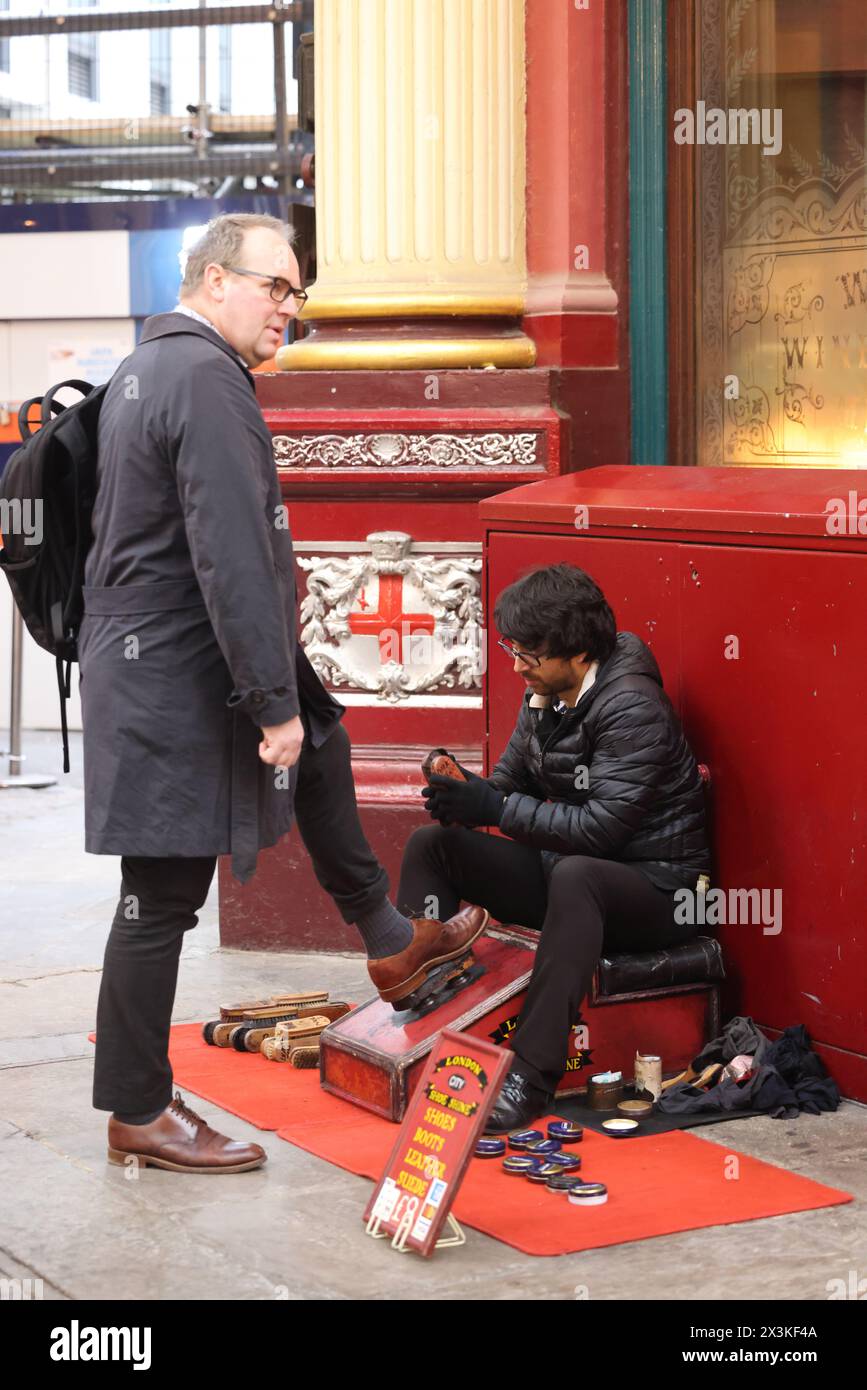 London City Shoe Shine operator at work polishing a man's shoes in ...