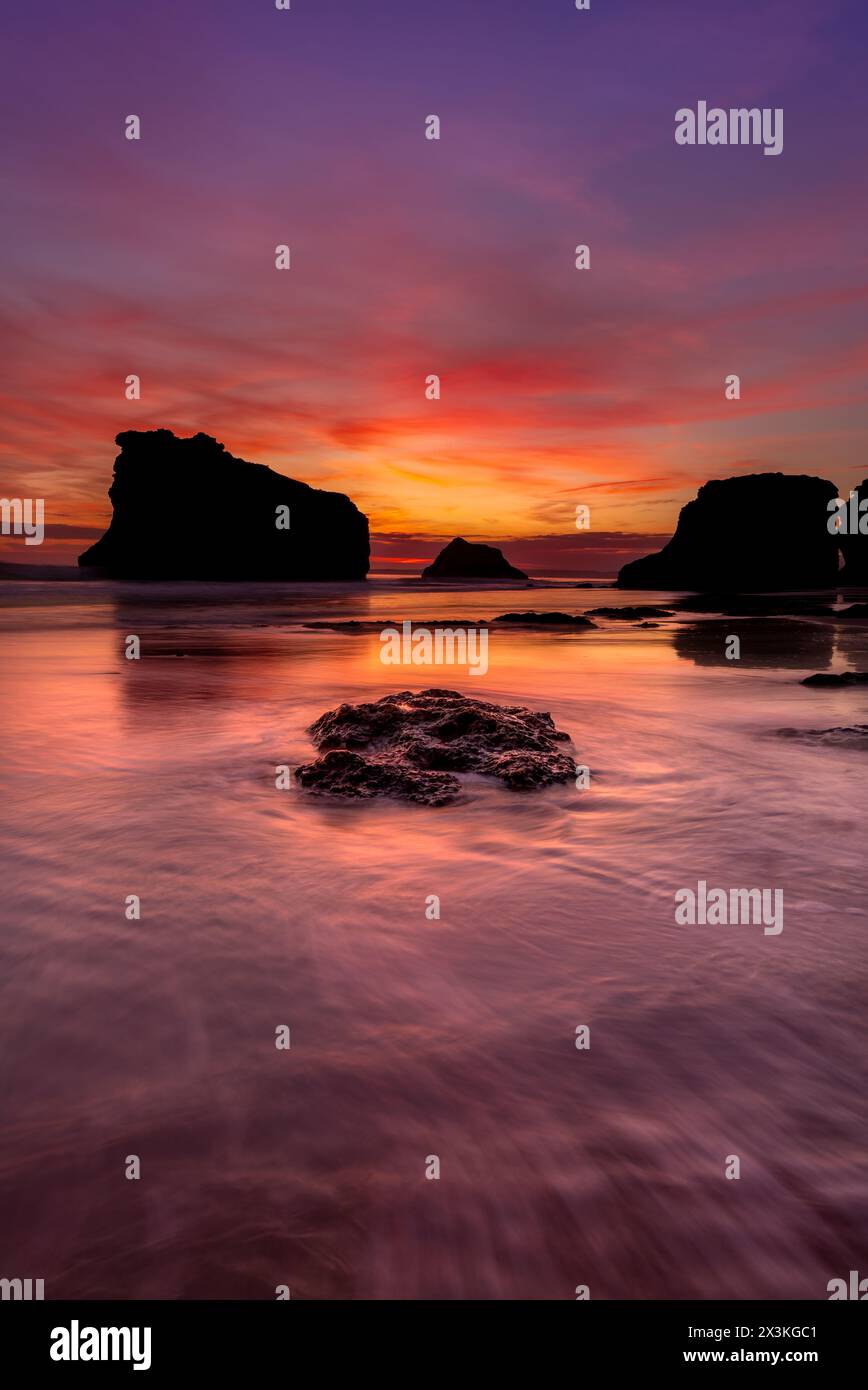 Colourful sunset silhoutte on Prainha, a beach in Alvor in the Algarve ...