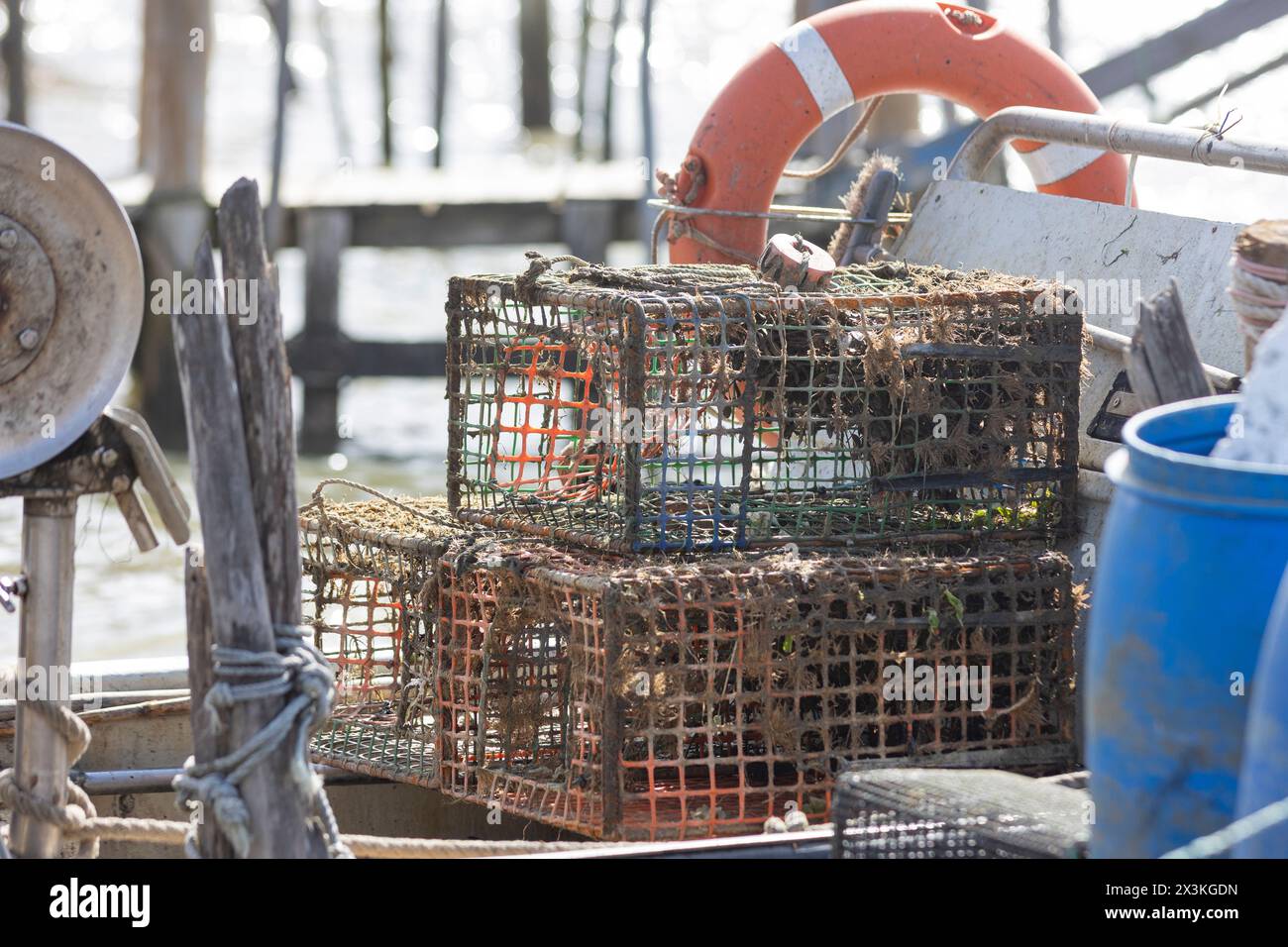 A boat with a blue container and two rusty fishing cages - trap for ...