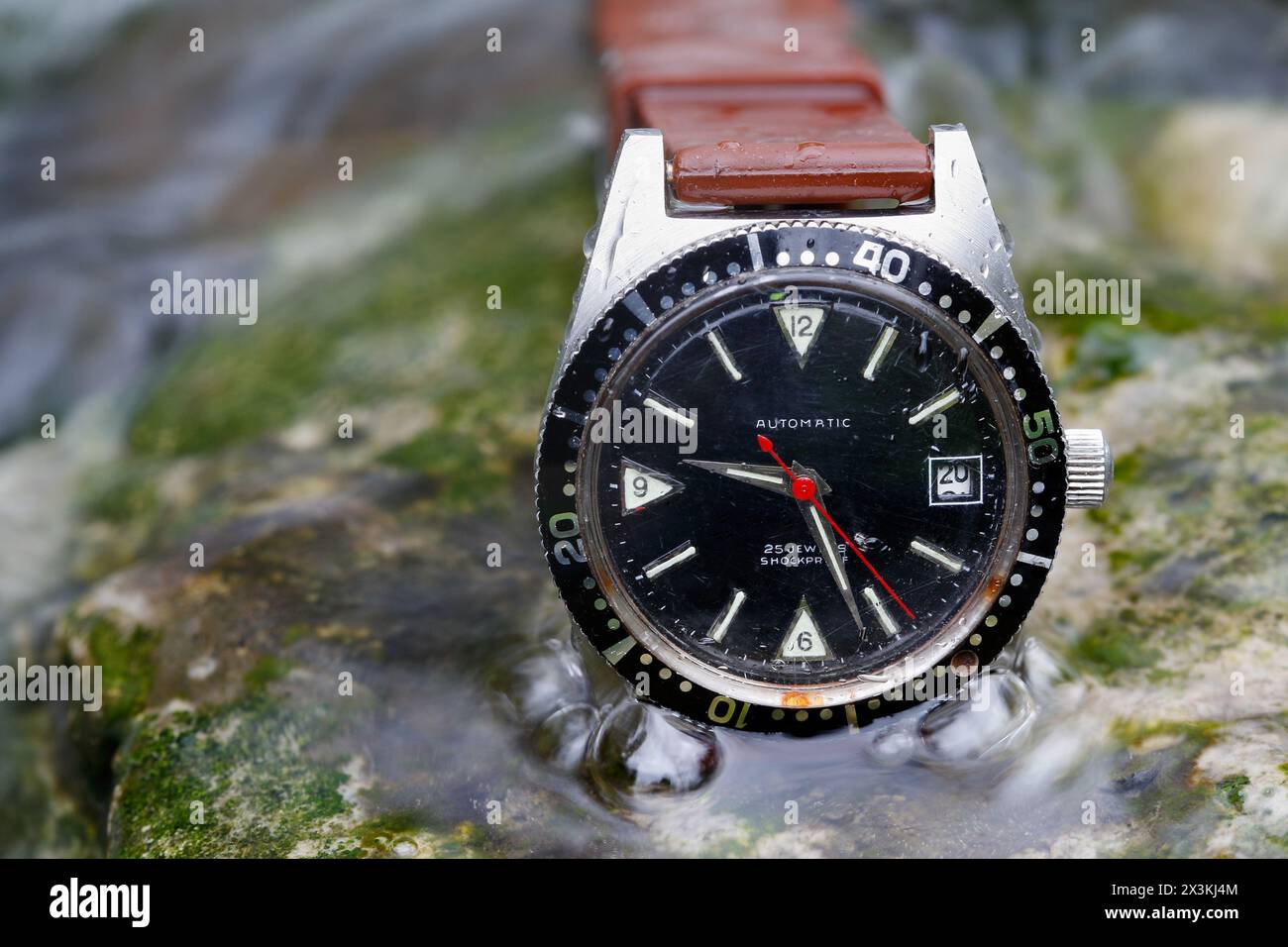 A robust, old mechanical watch defies the elements in the stream ...